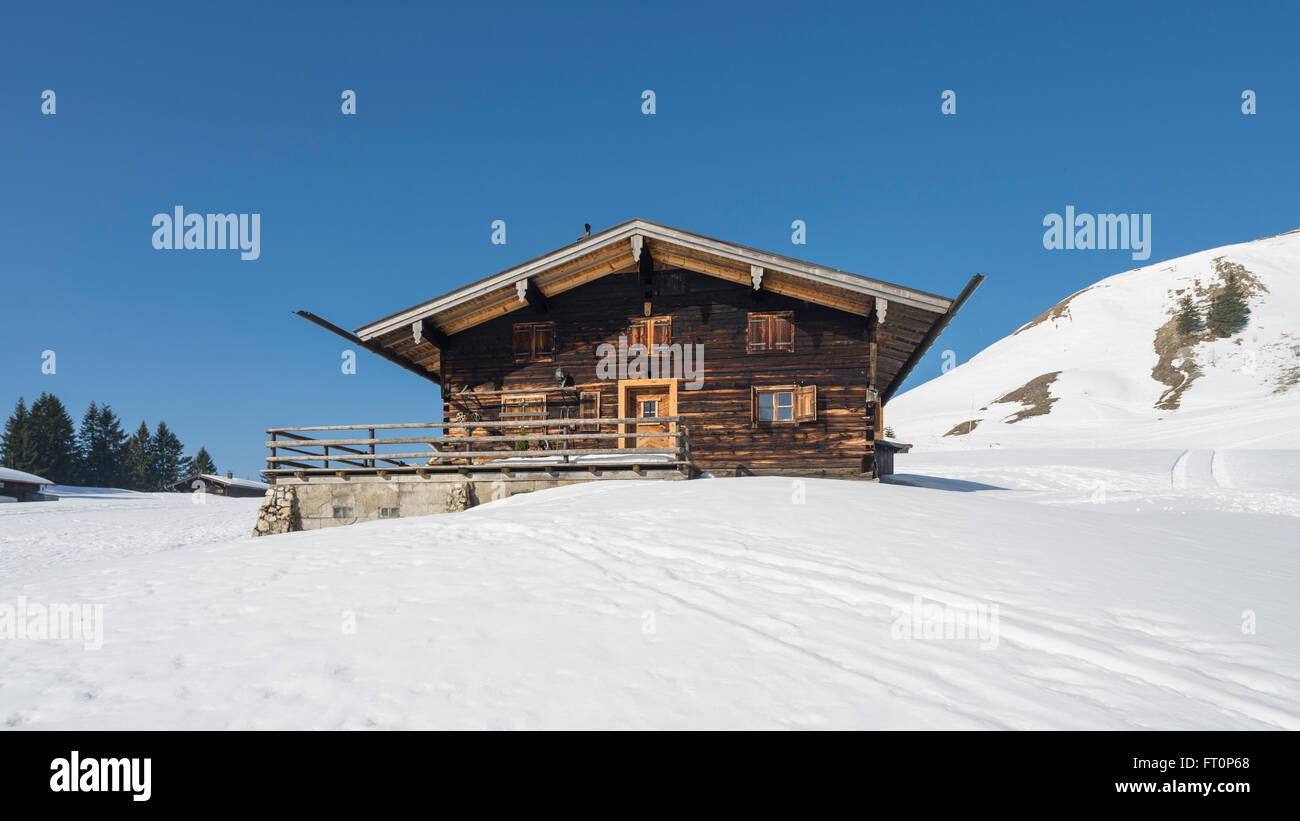 Alpine hut at Schoenfeldalm alp above Lake Spitzingsee still covered in ...