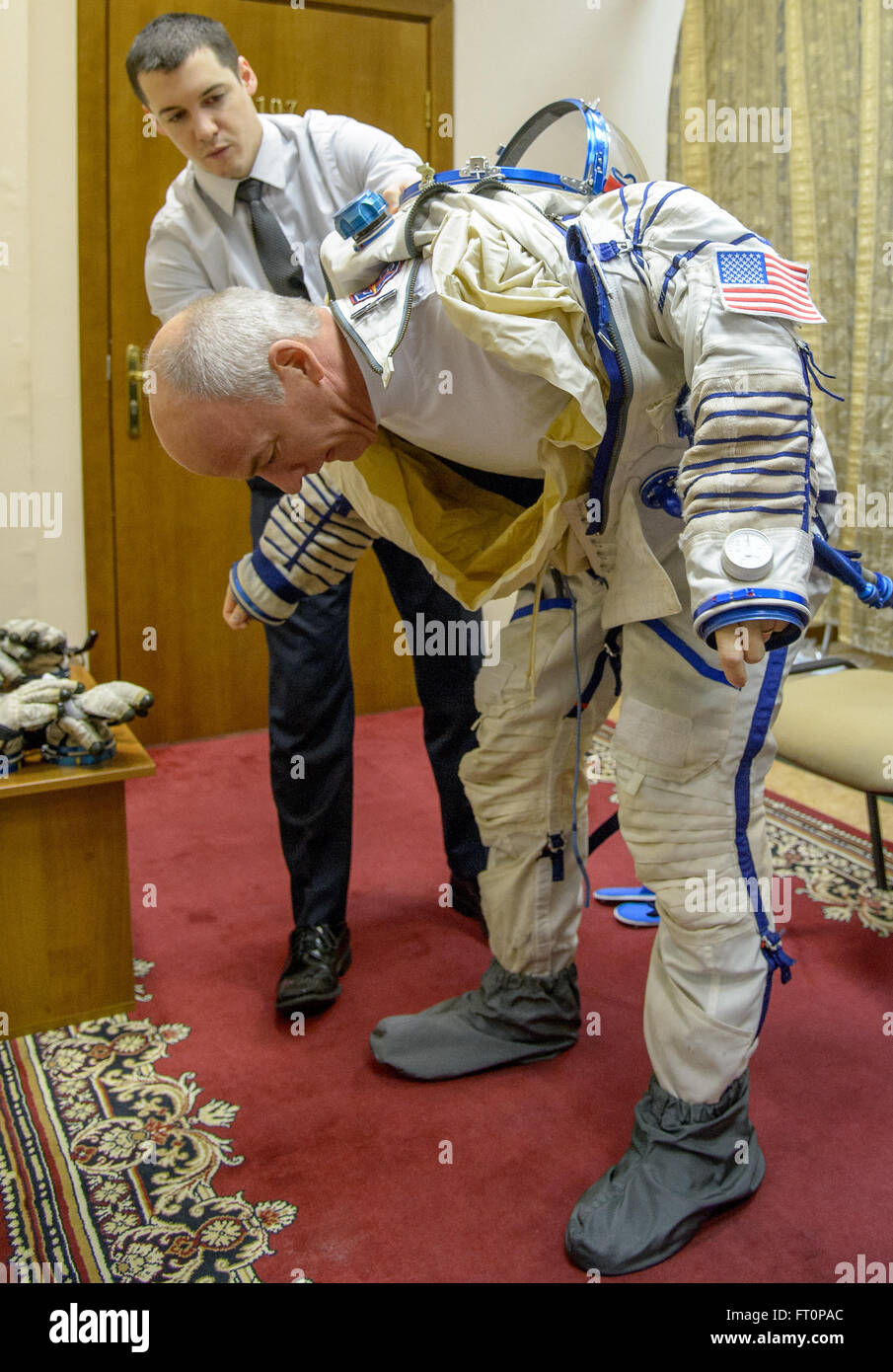 NASA astronaut Jeff Williams wears a Russian Sokol spacesuit with help ...