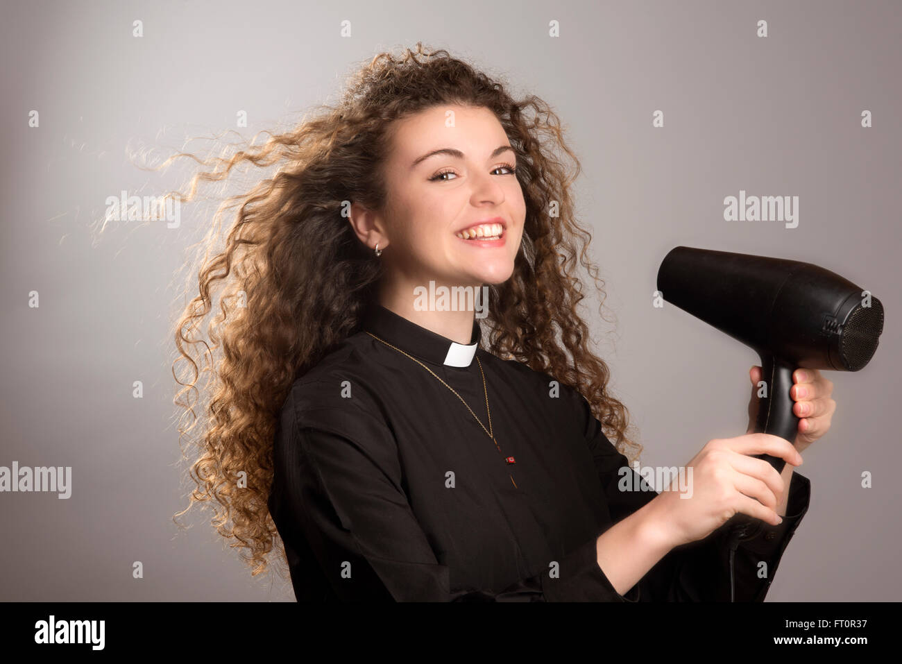 Woman priest with long hair using a hair dryer Stock Photo - Alamy