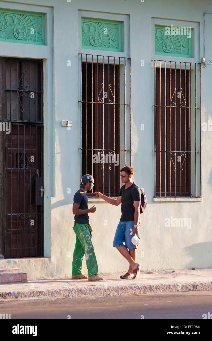 Two men standing talking outside building in street in Cuba Stock Photo ...