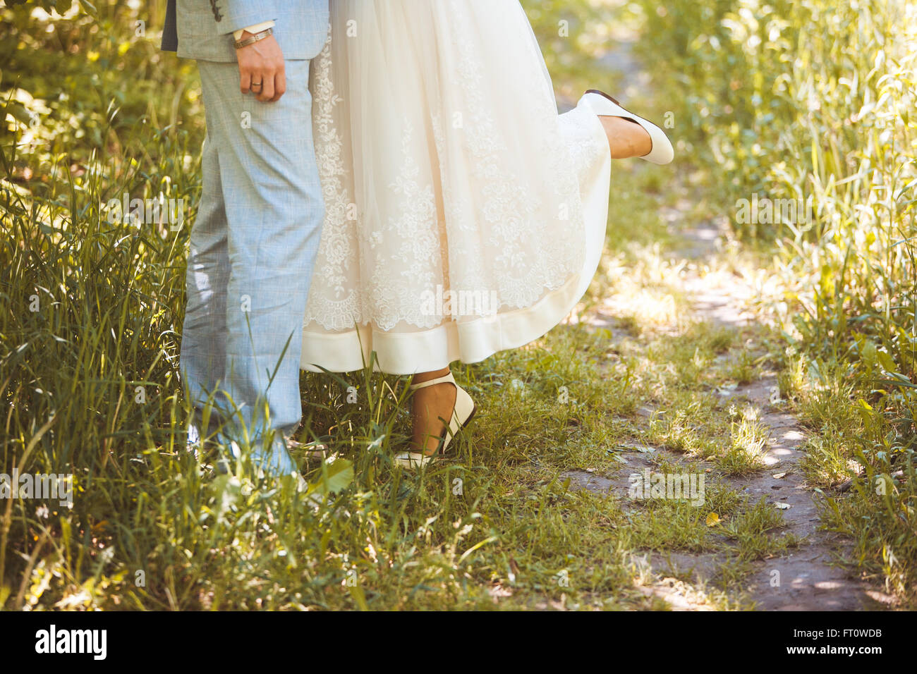 Among the tall grass are the bride and groom. Bride raised leg Stock ...