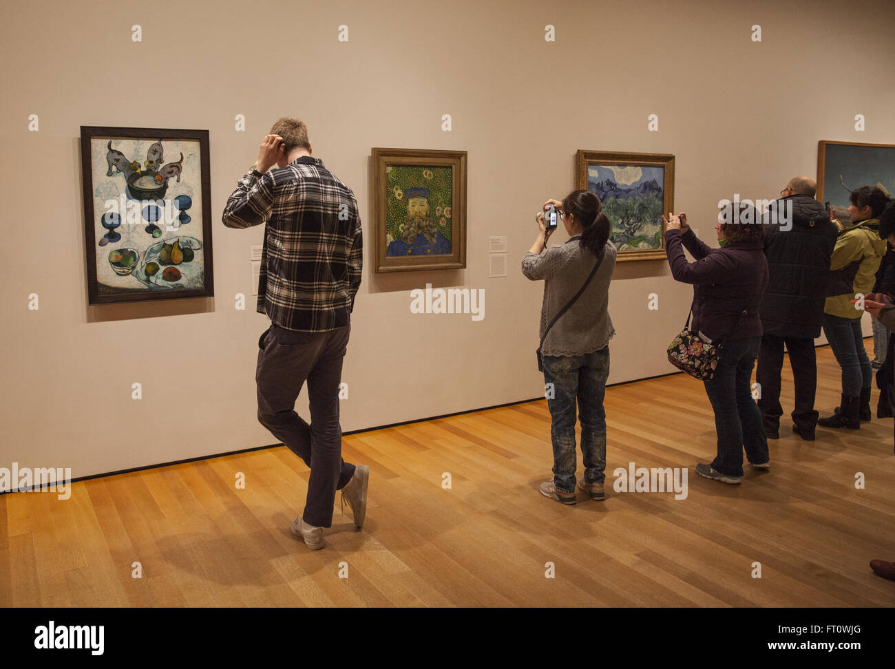 Museum goers contemplate and photograph van Gogh paintings at the ...