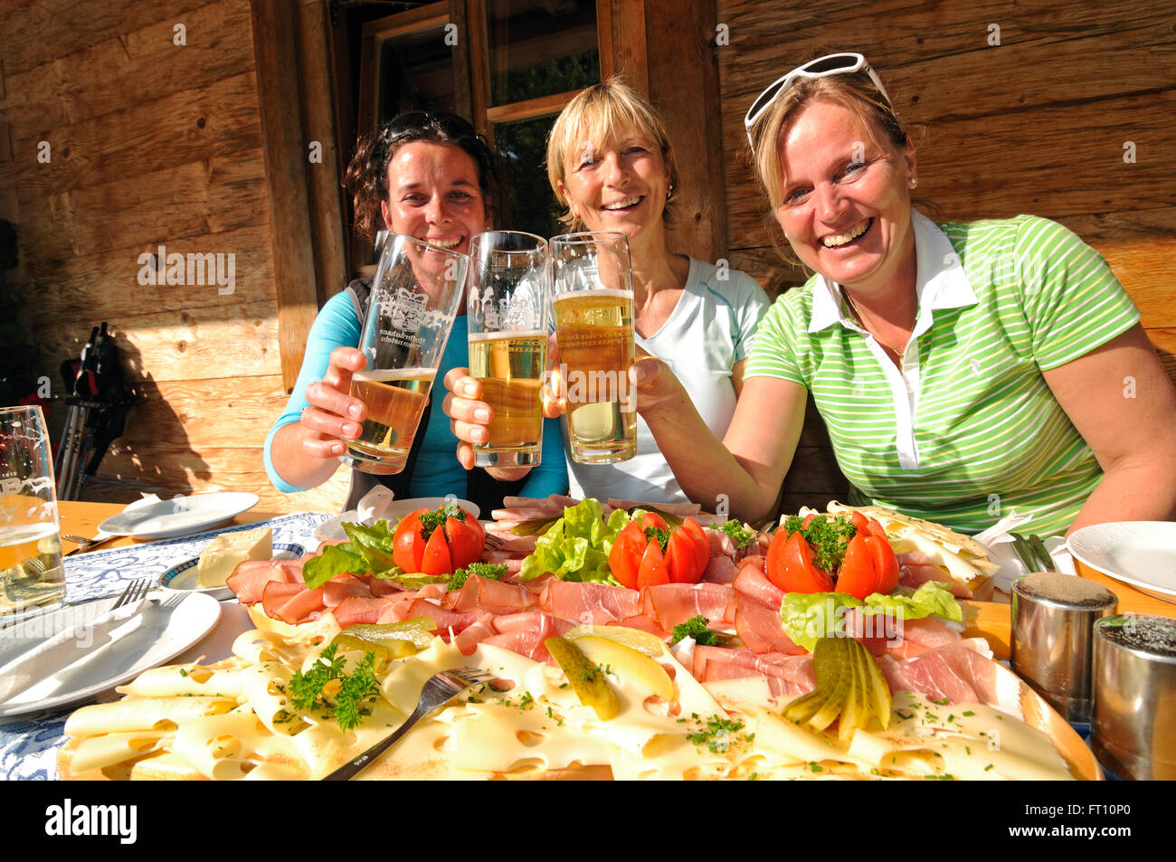 Three female hikers enjoying a snack Stock Photo - Alamy