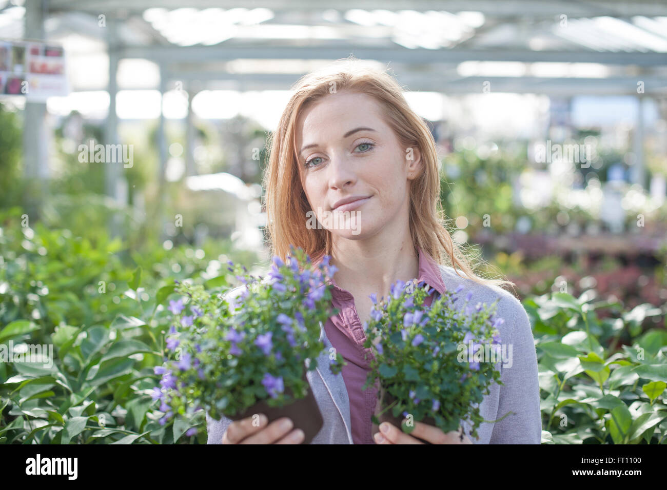young woman choosing some flowers to plant in her garden Stock Photo ...