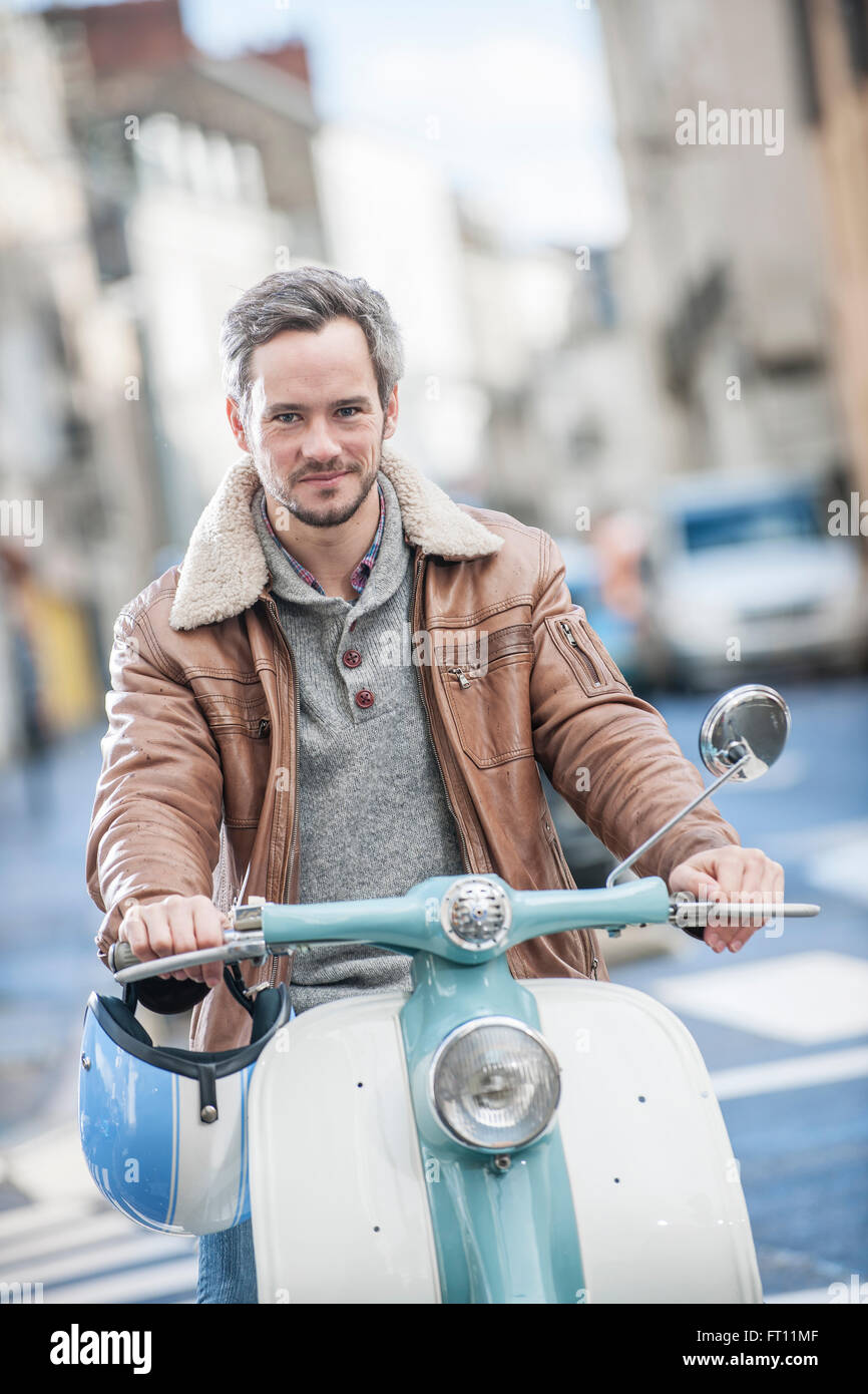 handsome man riding an old scooter in city Stock Photo - Alamy