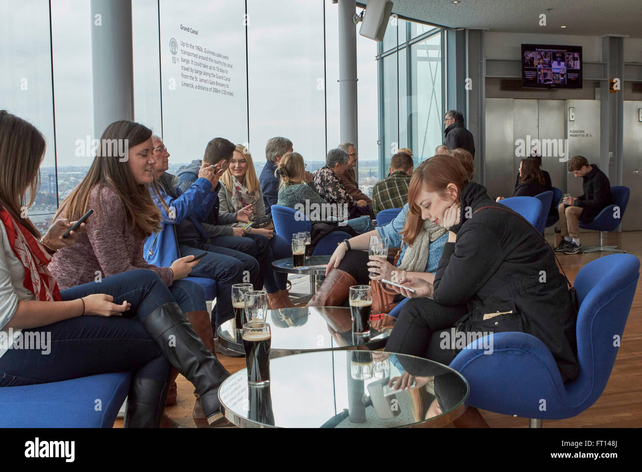 tourists enjoy a pint of guinness in the gravity bar guinness ...