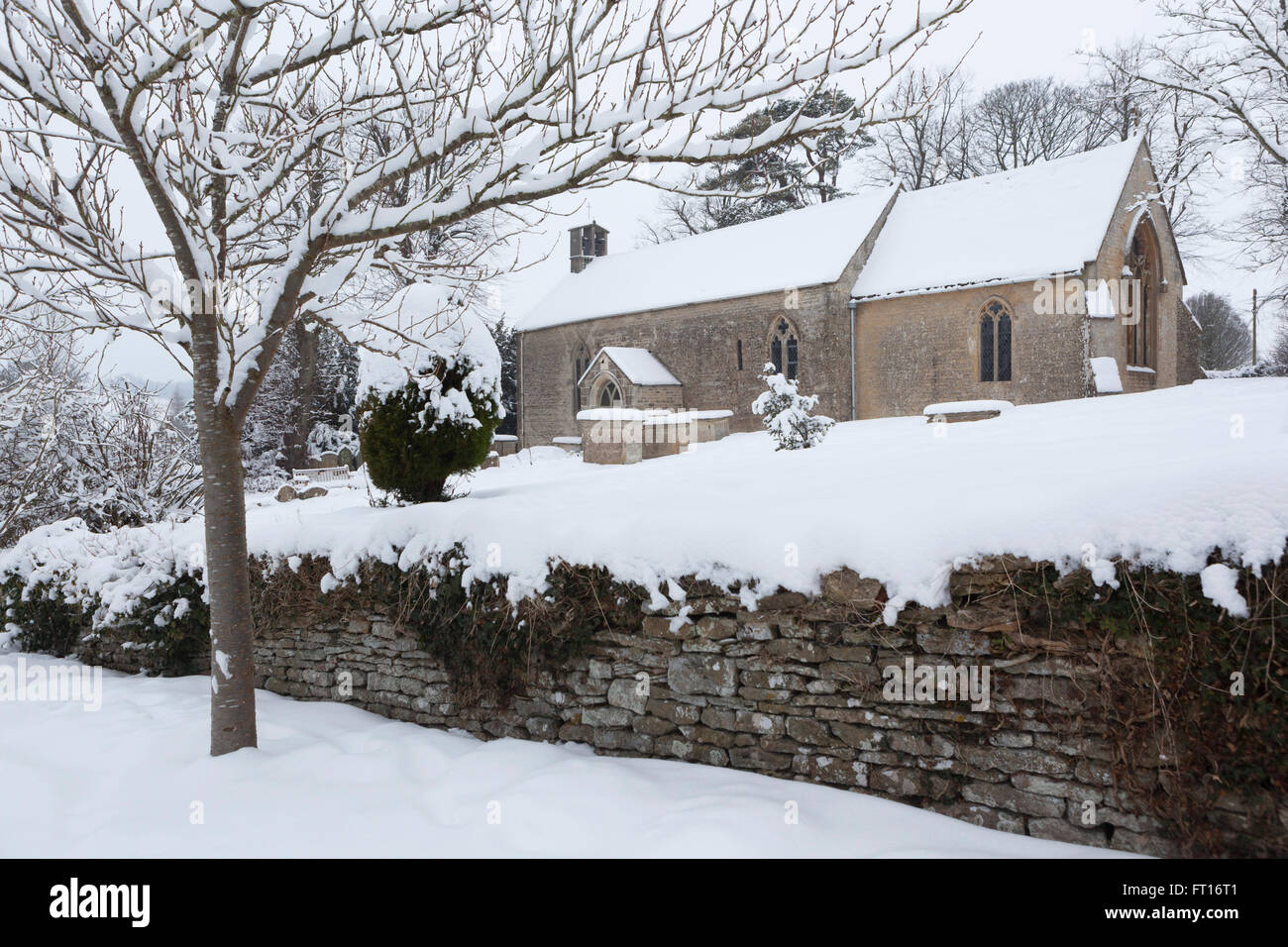 A church in a churchyard covered in snow during the winter at christmas ...