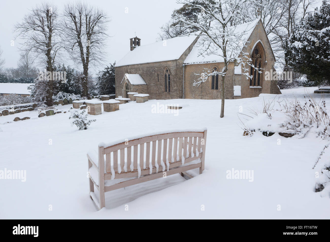A church in a churchyard covered in snow during the winter at christmas ...