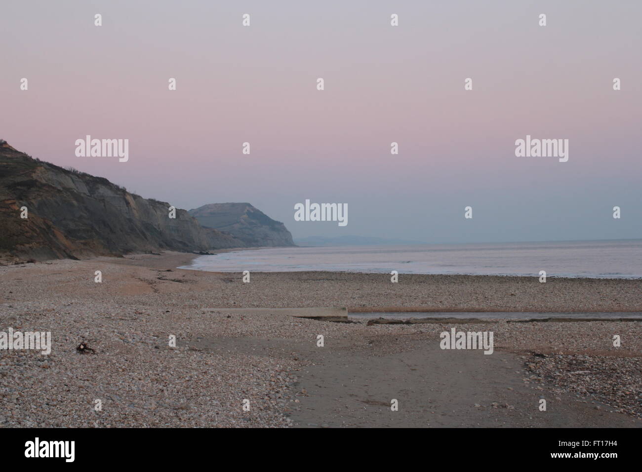 sunset over coast with cliff beach and sea Stock Photo - Alamy