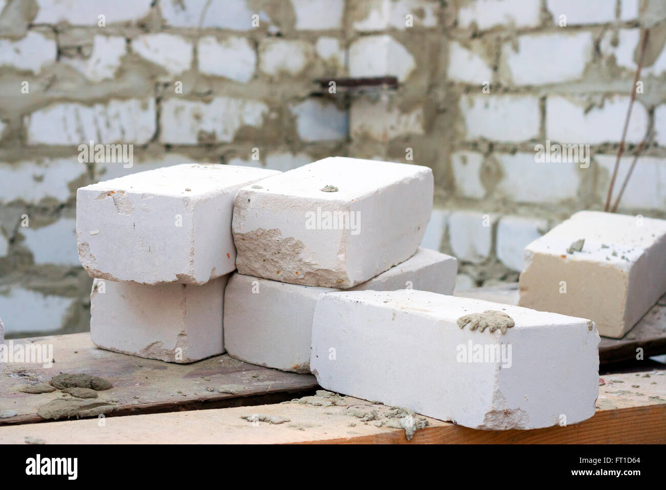 Some white bricks with background of building wall Stock Photo - Alamy