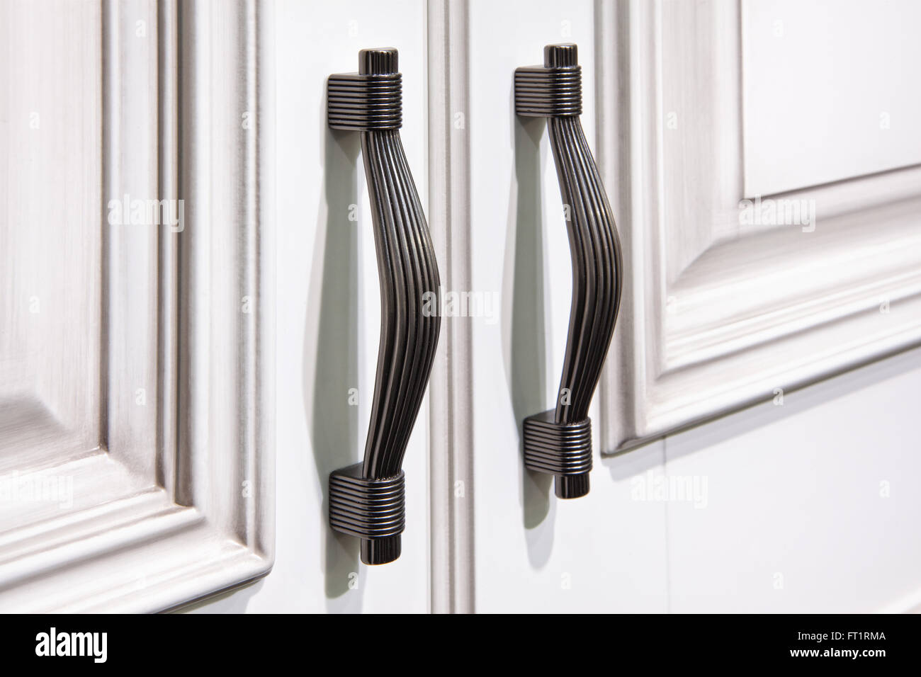 silver handles on cabinet doors Stock Photo - Alamy