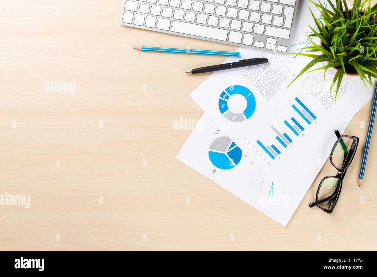 Office desk workplace with pc and charts on wooden table. Top view with ...