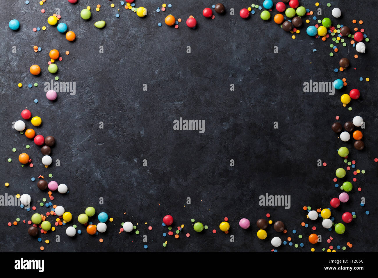 Colorful candies frame on stone background Stock Photo - Alamy