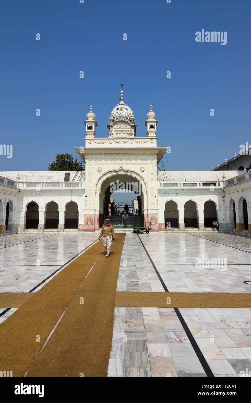Crowds of Sikh pilgrims enter through the white marble gateway to ...