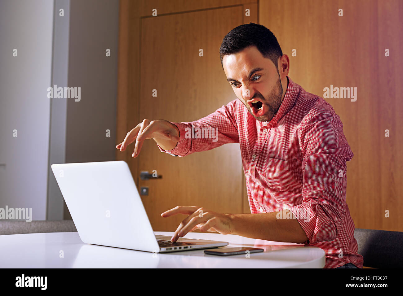 Male angry student work on computer touch pad, young angry business man ...