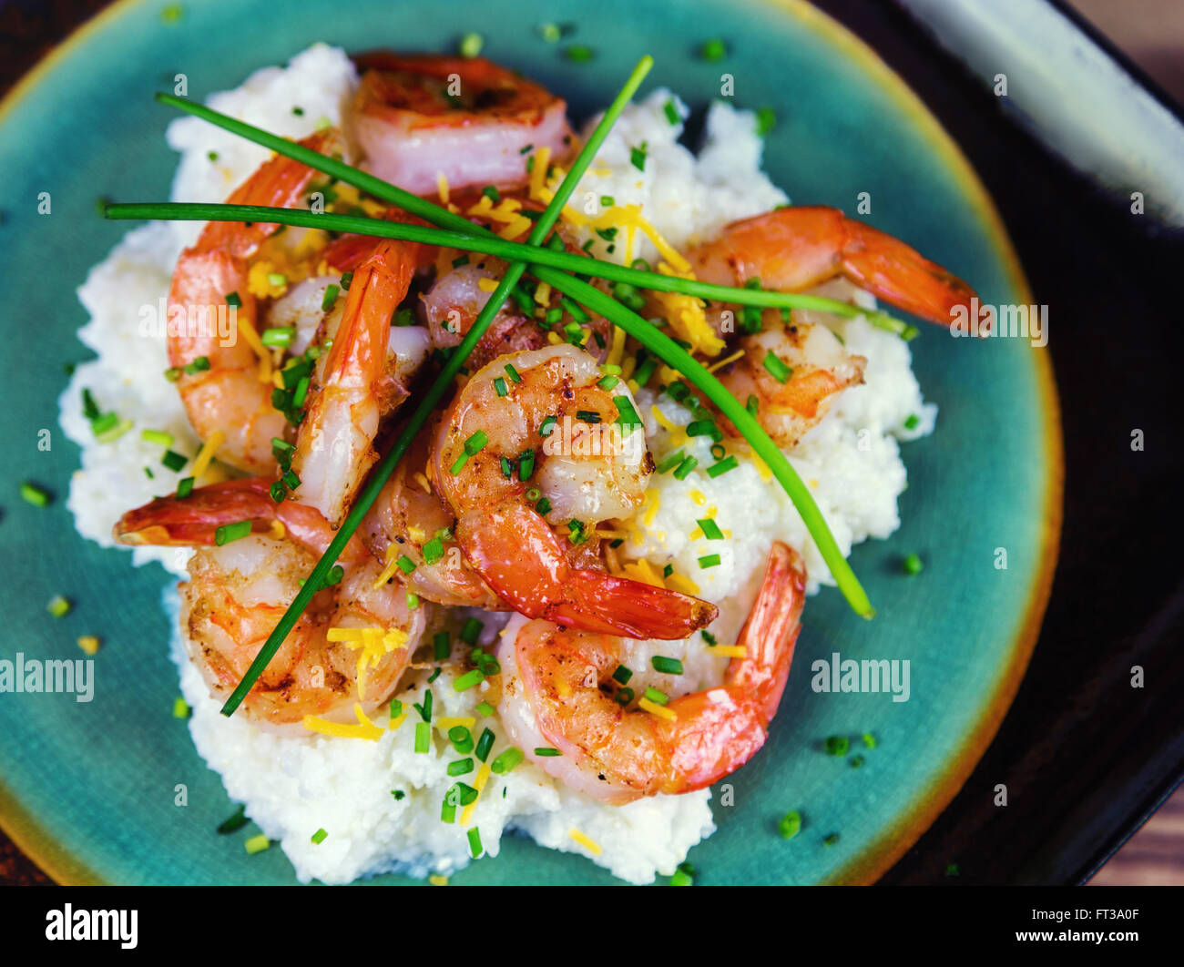 Shrimp and grits on a square plate with turquoise center Stock Photo ...