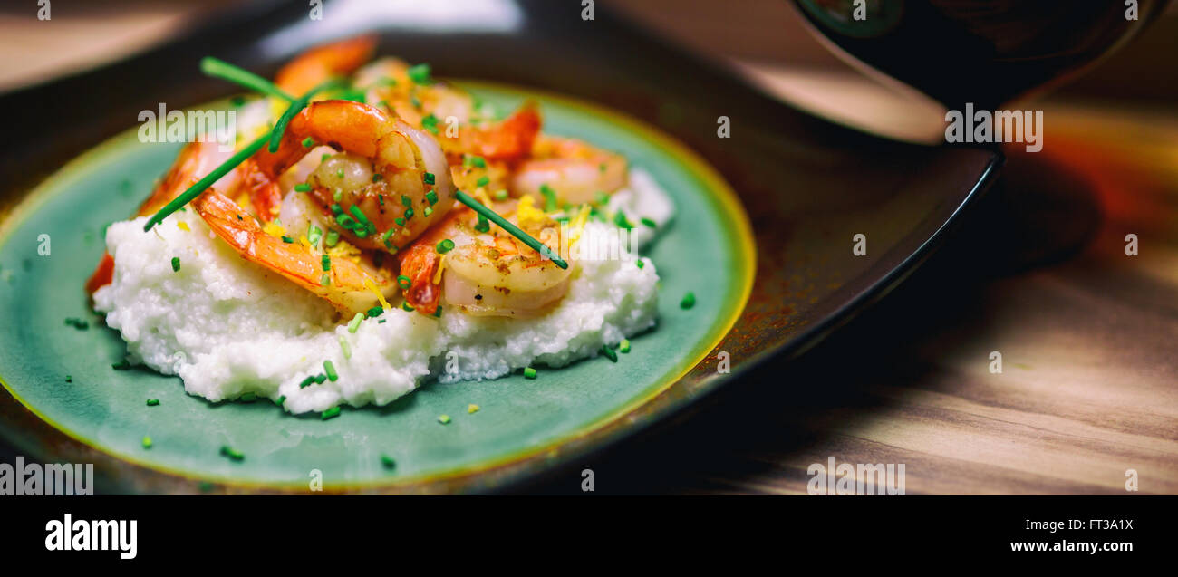 Shrimp and grits on a square plate with turquoise center Stock Photo ...