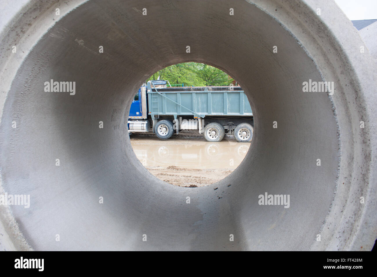 looking through a precast concrete drainage pipe at a construction ...