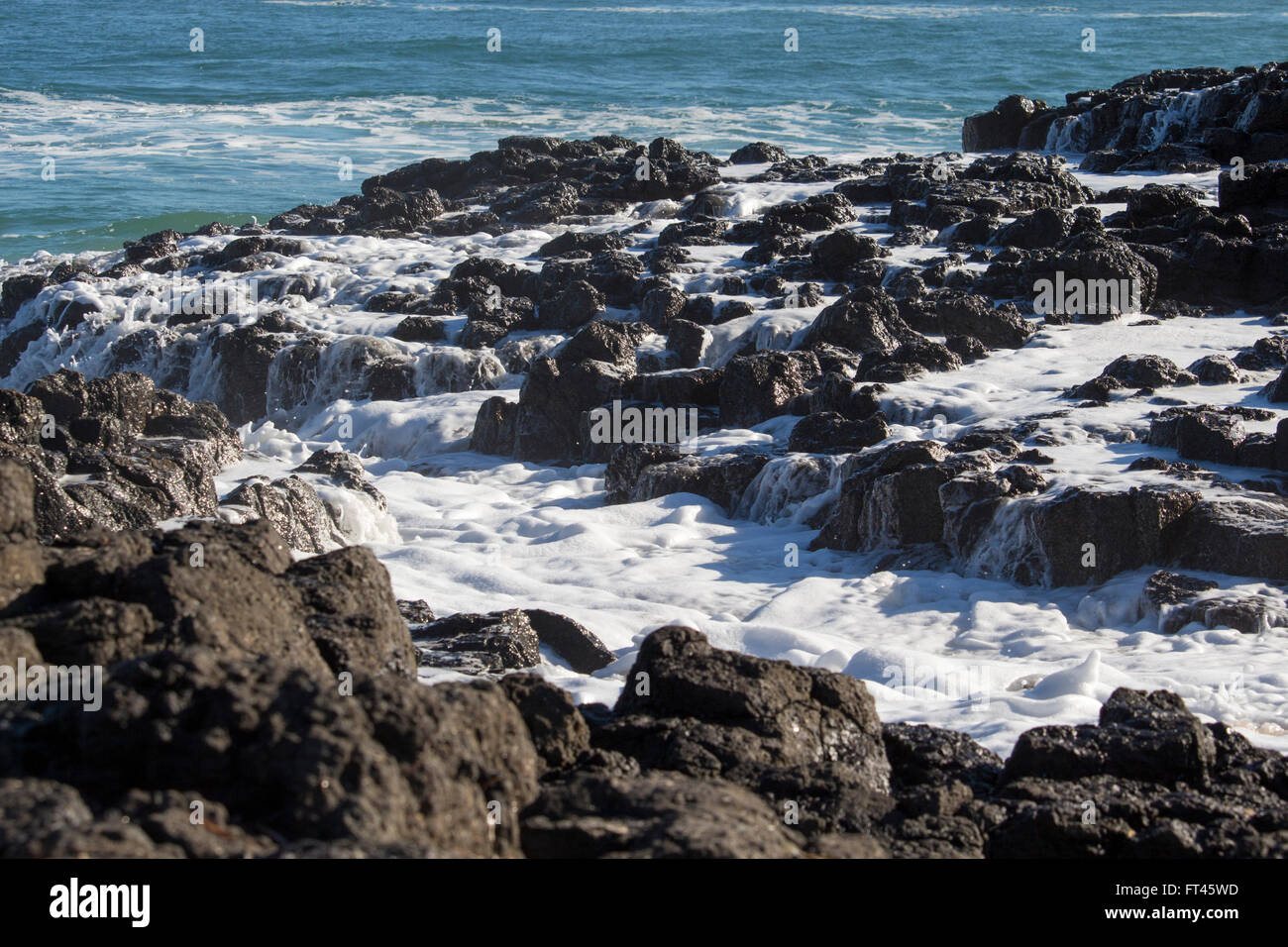 Splashing, foaming white backwash from the Indian Ocean waves breaking ...
