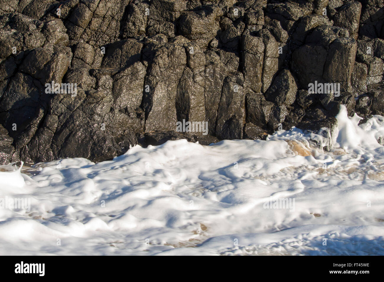 Splashing, foaming white backwash from the Indian Ocean waves breaking ...