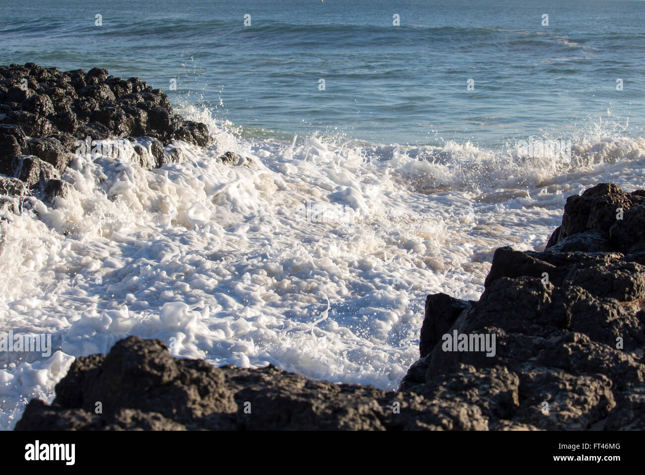 Splashing, foaming white backwash from the Indian Ocean waves breaking ...