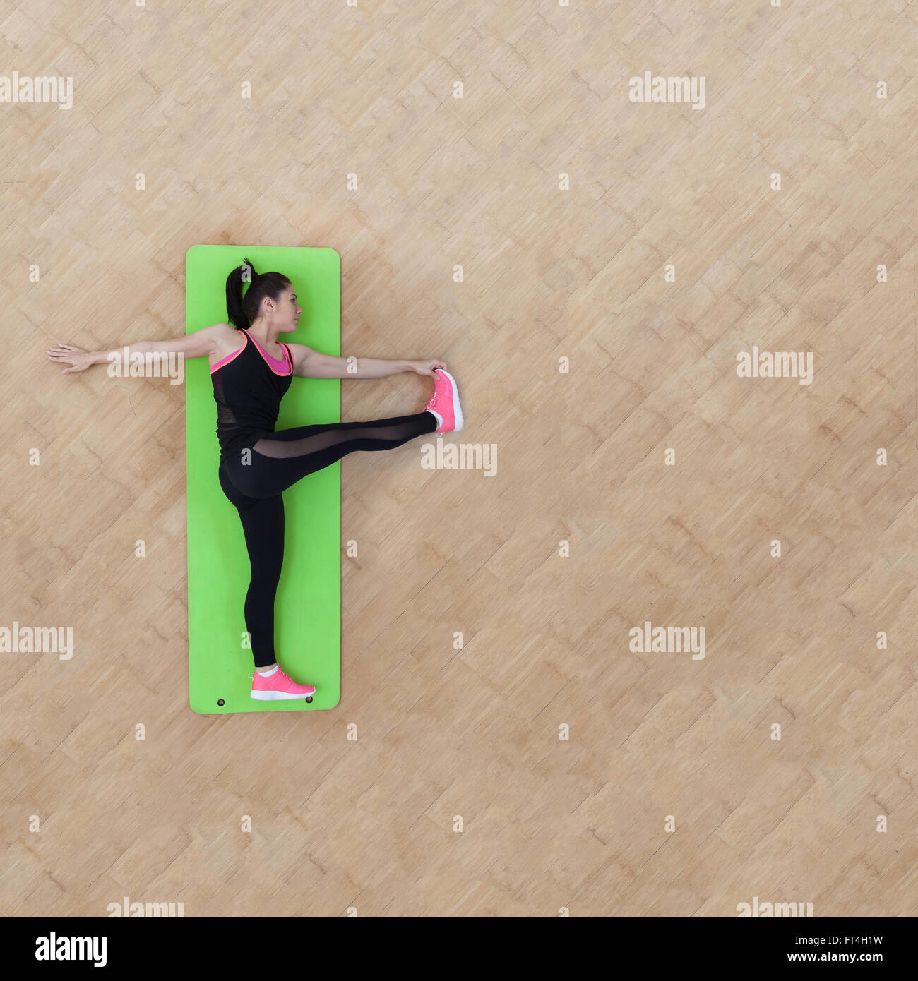 Fitness woman doing stretching exercises on mat. Above image with copy ...