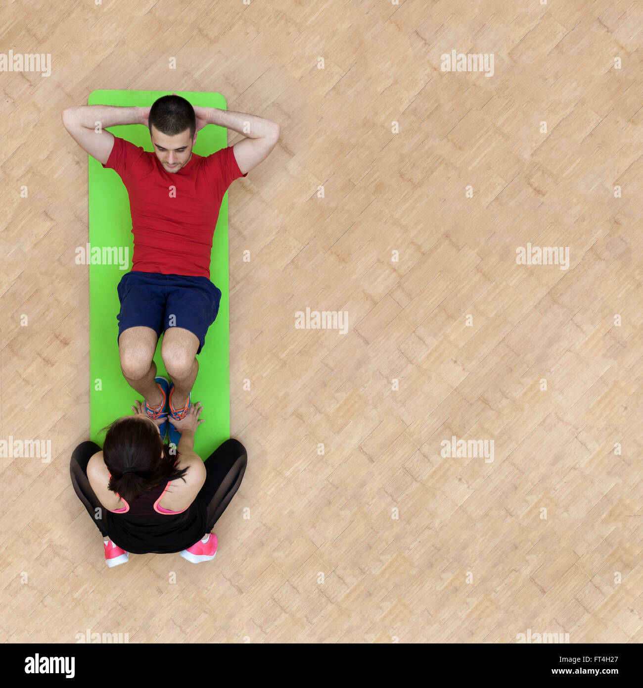 Fitness couple doing abs exercises on mat. Above image with copy space ...
