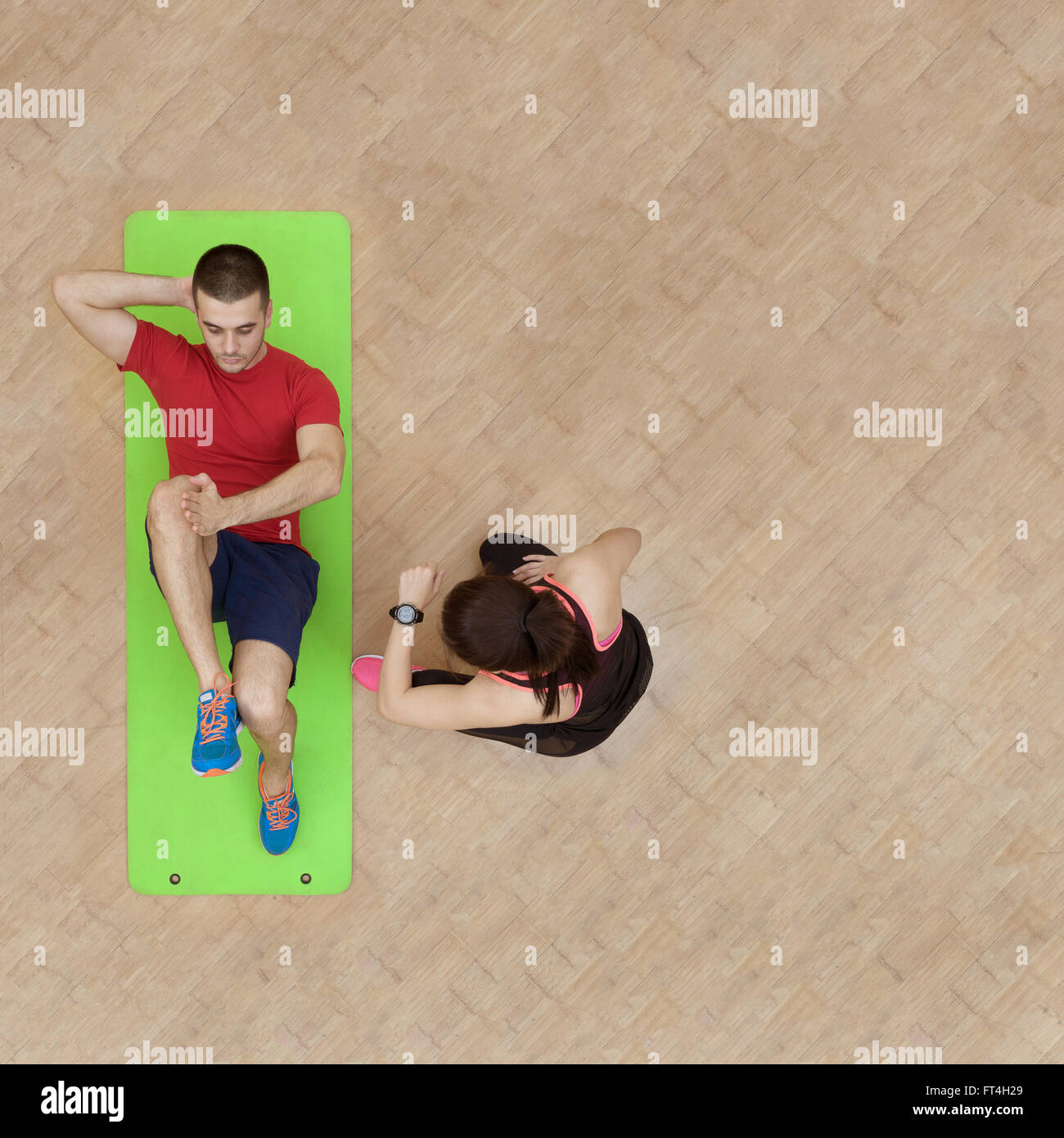 Fitness couple doing abs exercises on mat. Above image with copy space ...