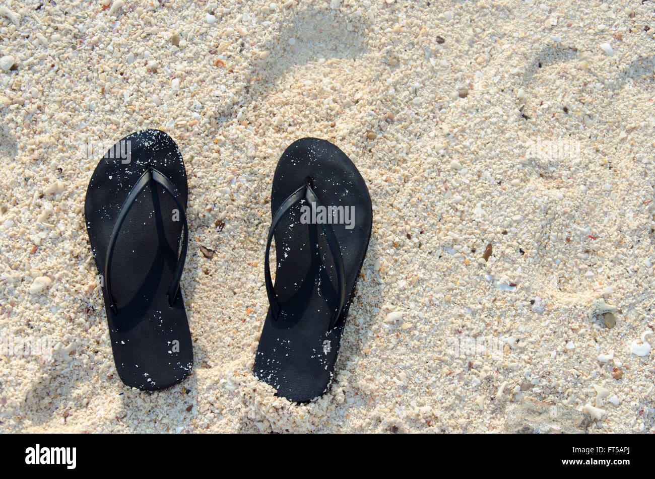Black slippers on tropical beach in holiday Stock Photo - Alamy