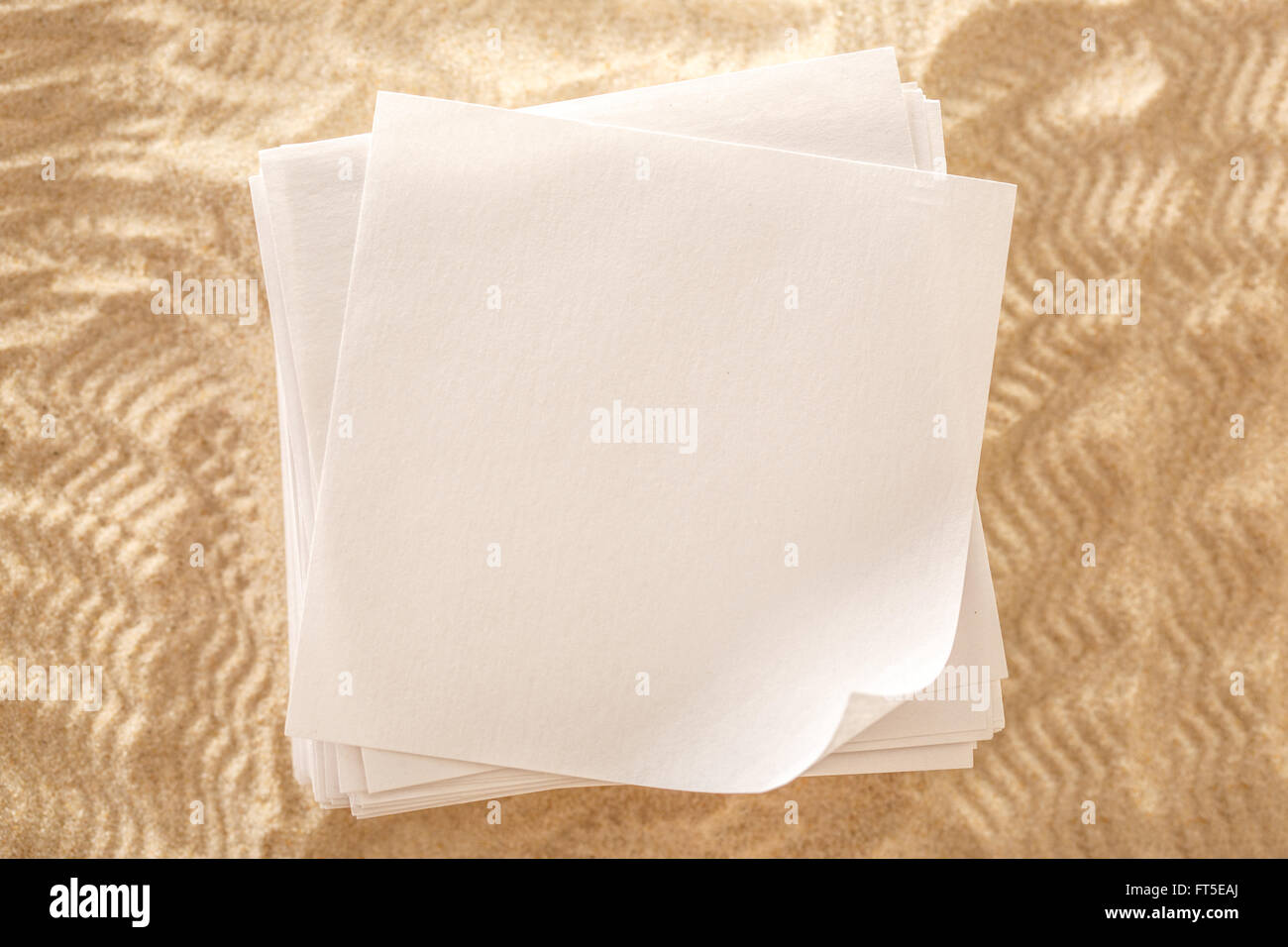 Blank sheets of paper on sand background Stock Photo - Alamy