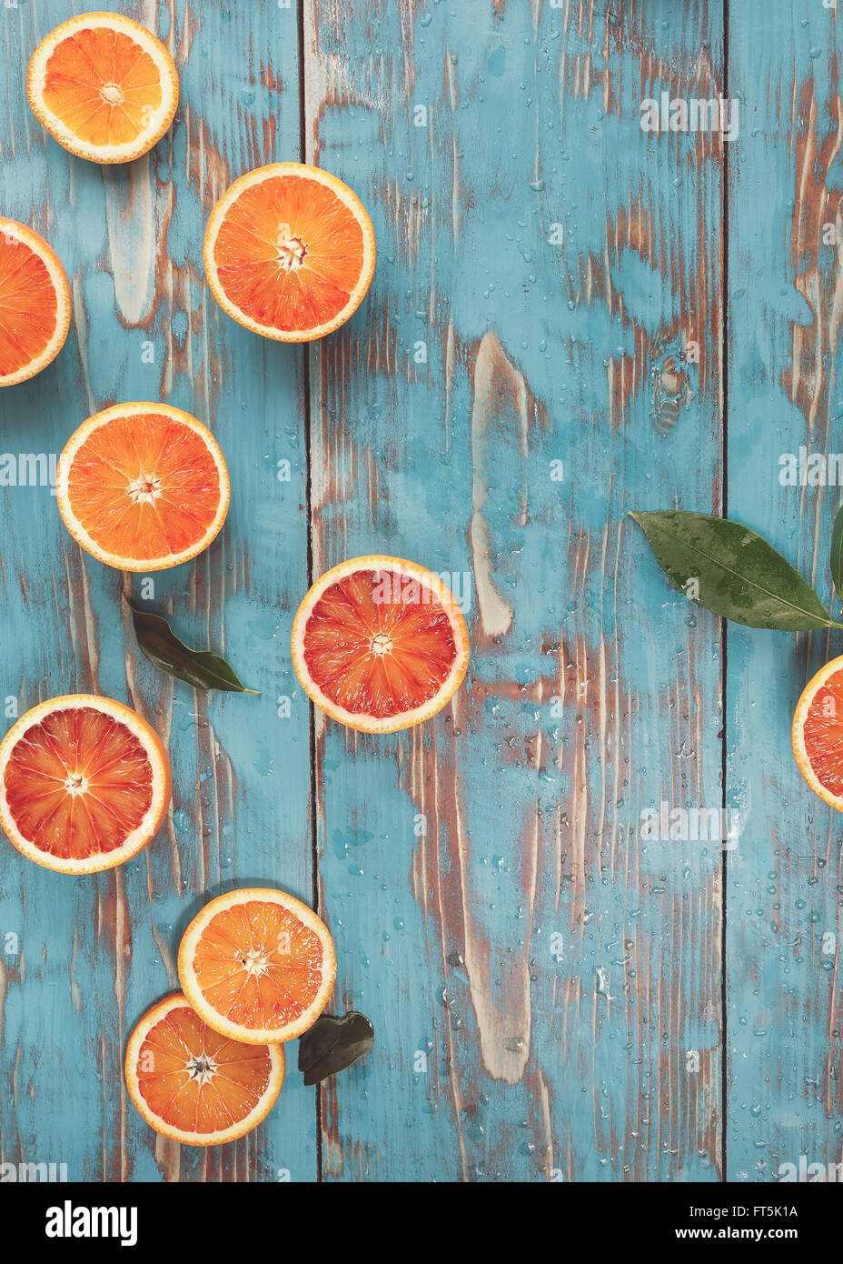 Blood Oranges. Halved blood oranges scattered on a turquoise rustic ...