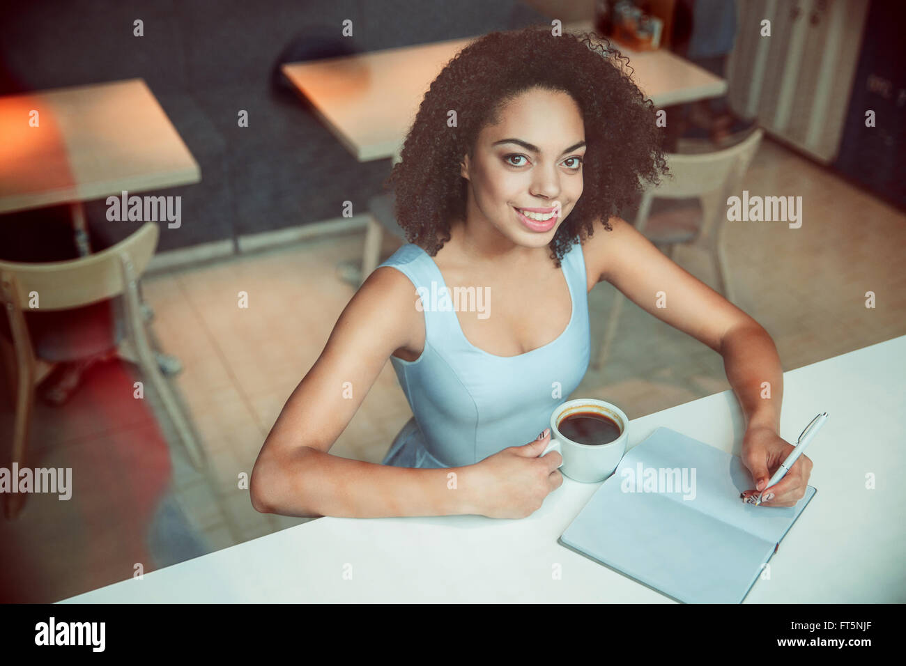 Smiling girl making notes Stock Photo - Alamy