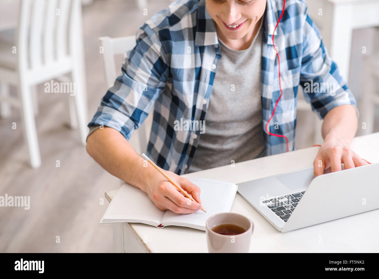 Cheerful guy making notes Stock Photo - Alamy