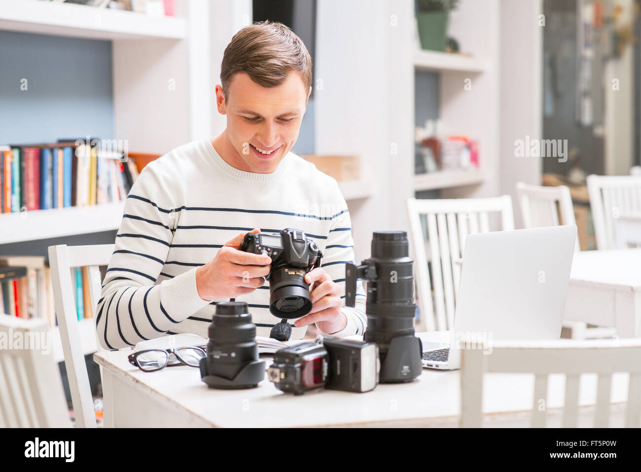 Pleasant guy holding photo camera Stock Photo - Alamy