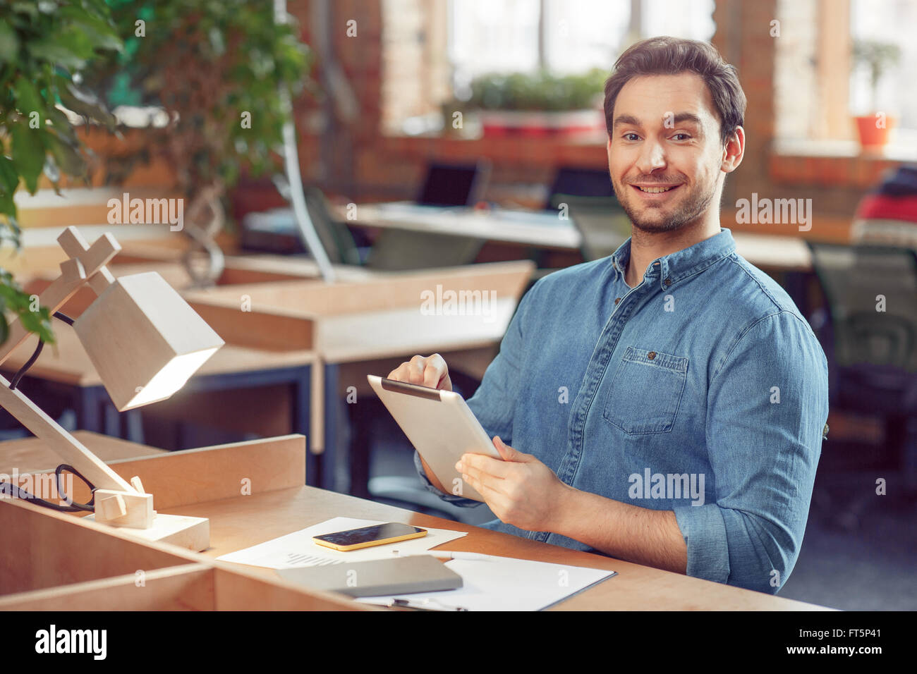 Pleasant man sitting at the table Stock Photo - Alamy