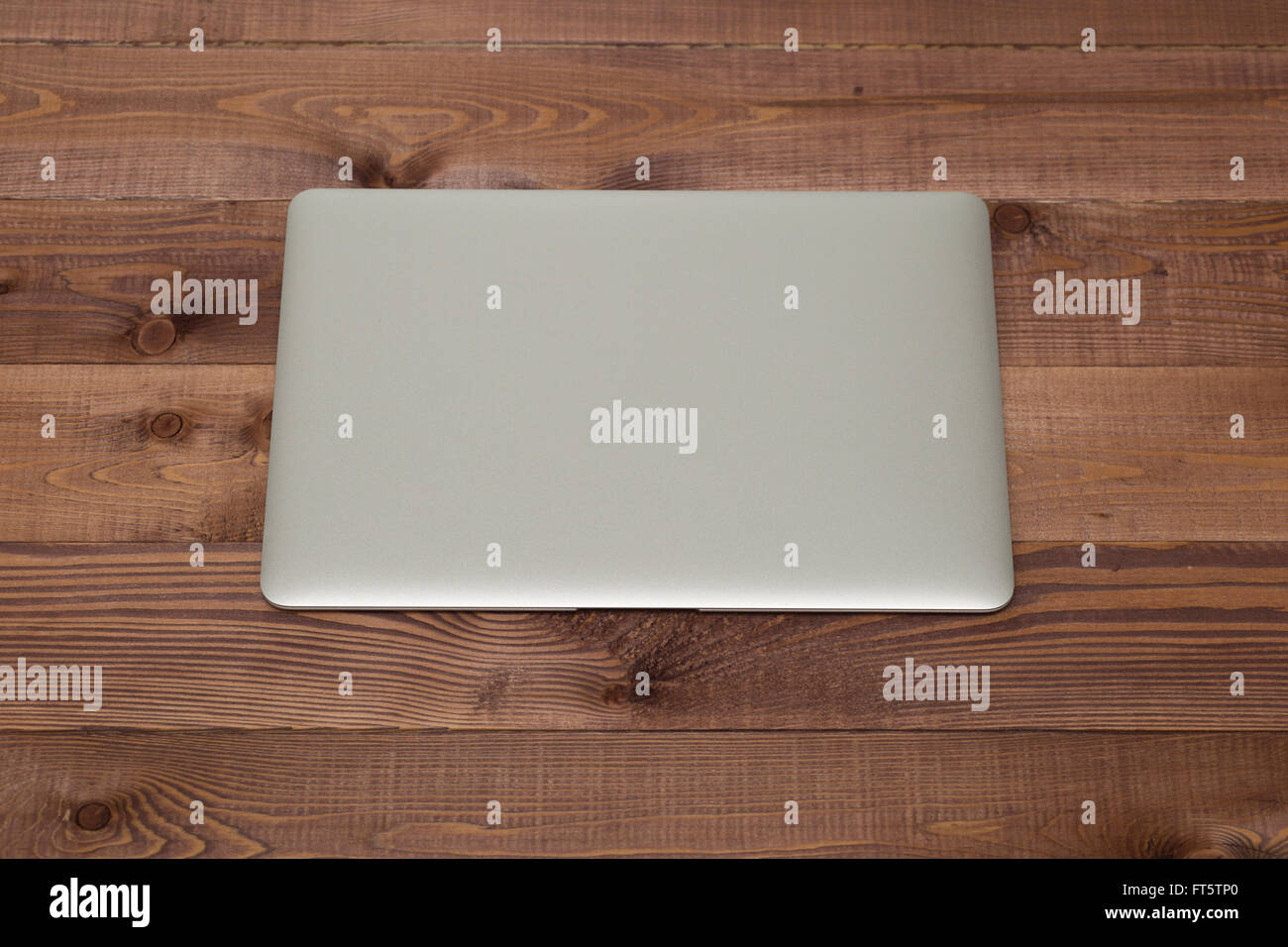 Closed silver laptop on brown wooden table, top view Stock Photo - Alamy