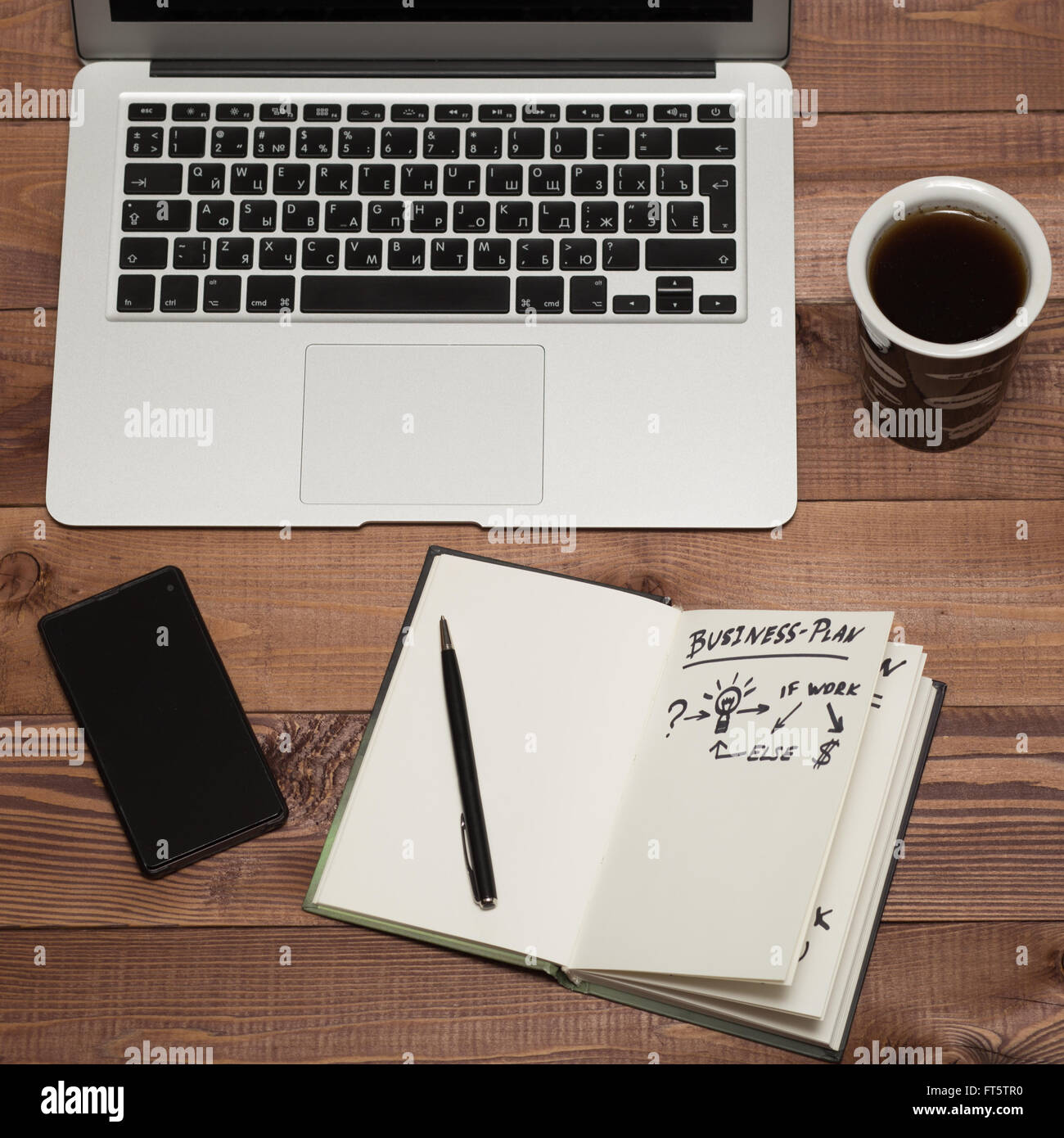 Wooden table, top view. On the table are, gadgets, pens, notebook for ...