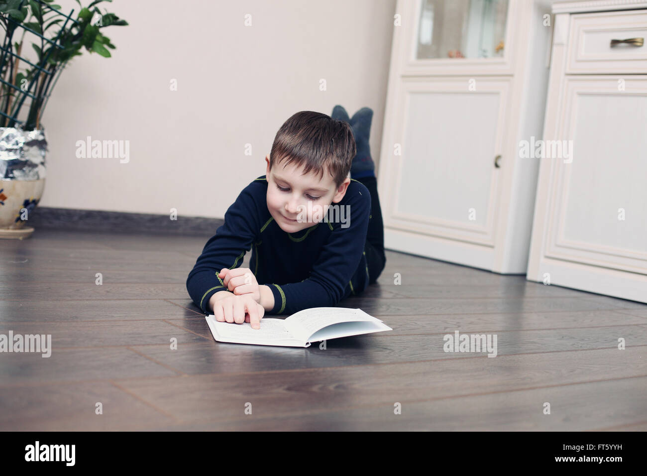 Child reeding book lying on the floor Stock Photo - Alamy