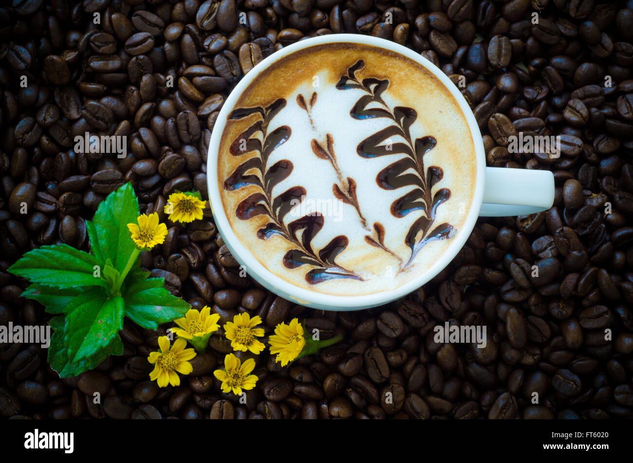 Closeup of a beautiful cup of latte art on coffee bean background Stock ...