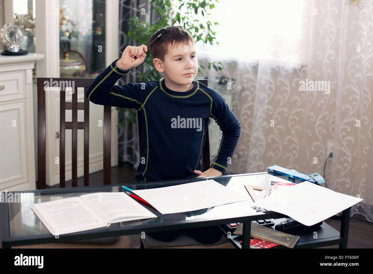 Boy does homework on a table at home Stock Photo - Alamy