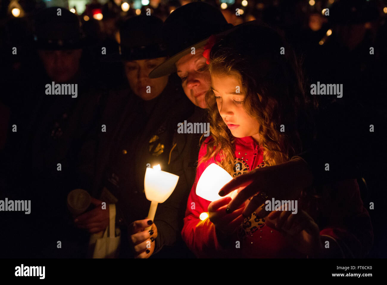 A young child lights a candle in remembrance of a fallen officer at the ...