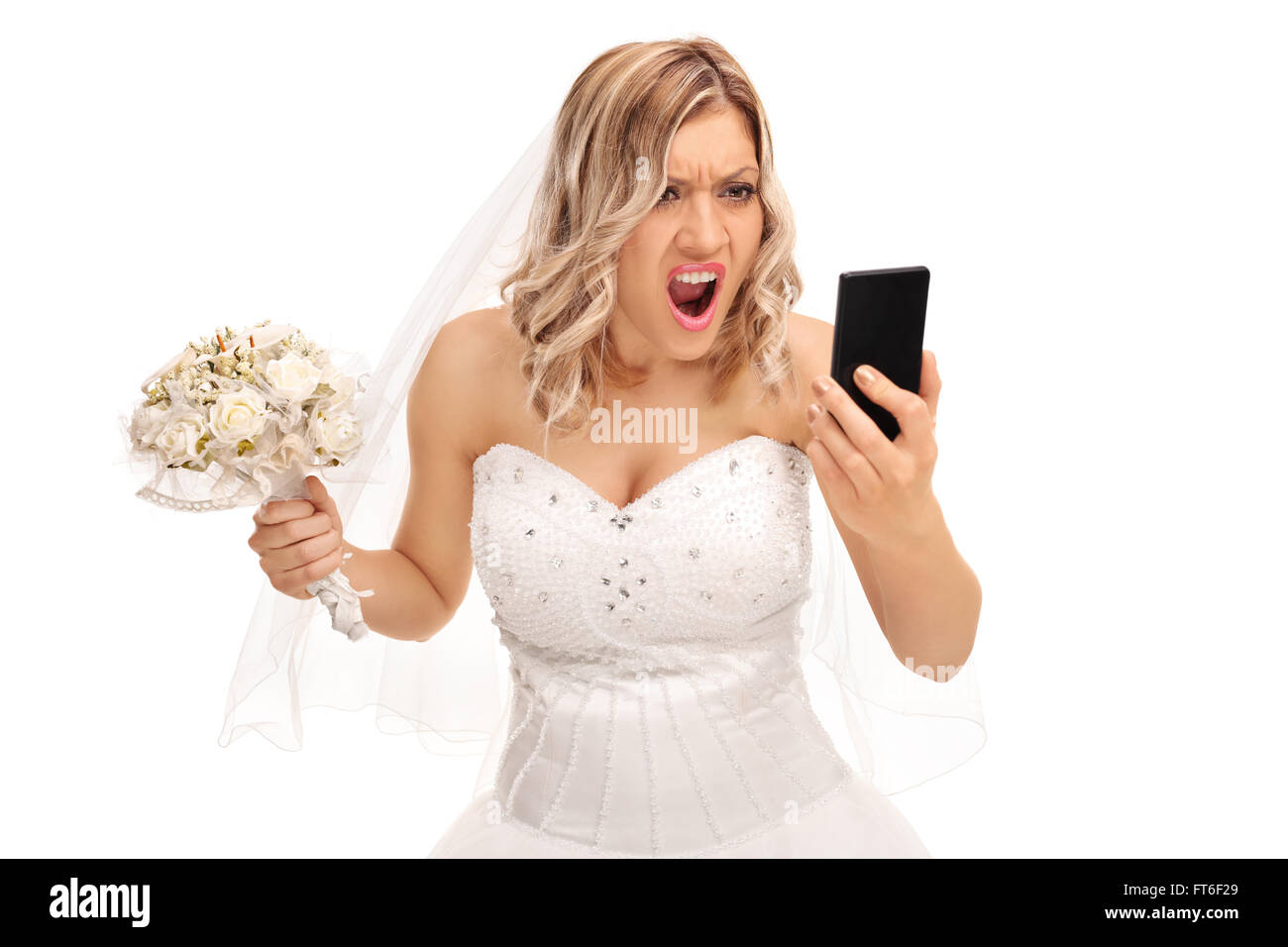 Furious young bride looking at her cell phone and screaming isolated on ...