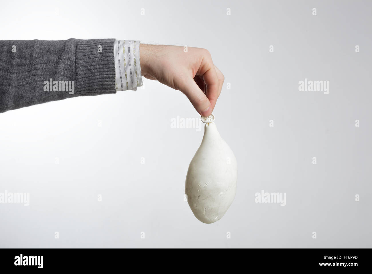 Man holding white balloon in hand Stock Photo - Alamy