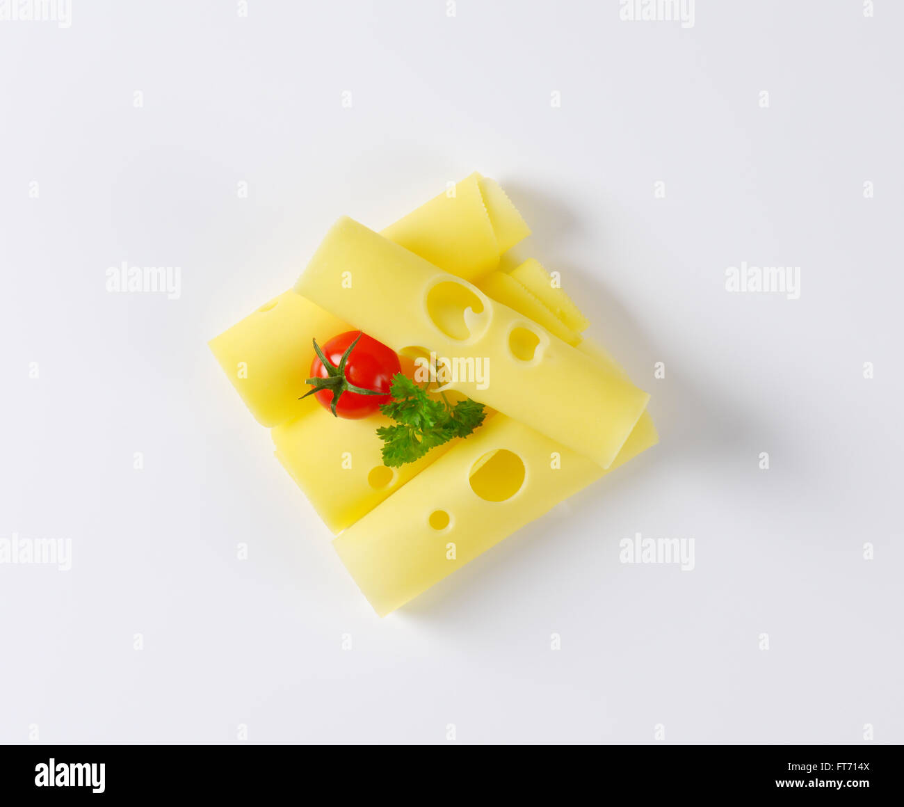 four rolled slices of emmental cheese Stock Photo - Alamy