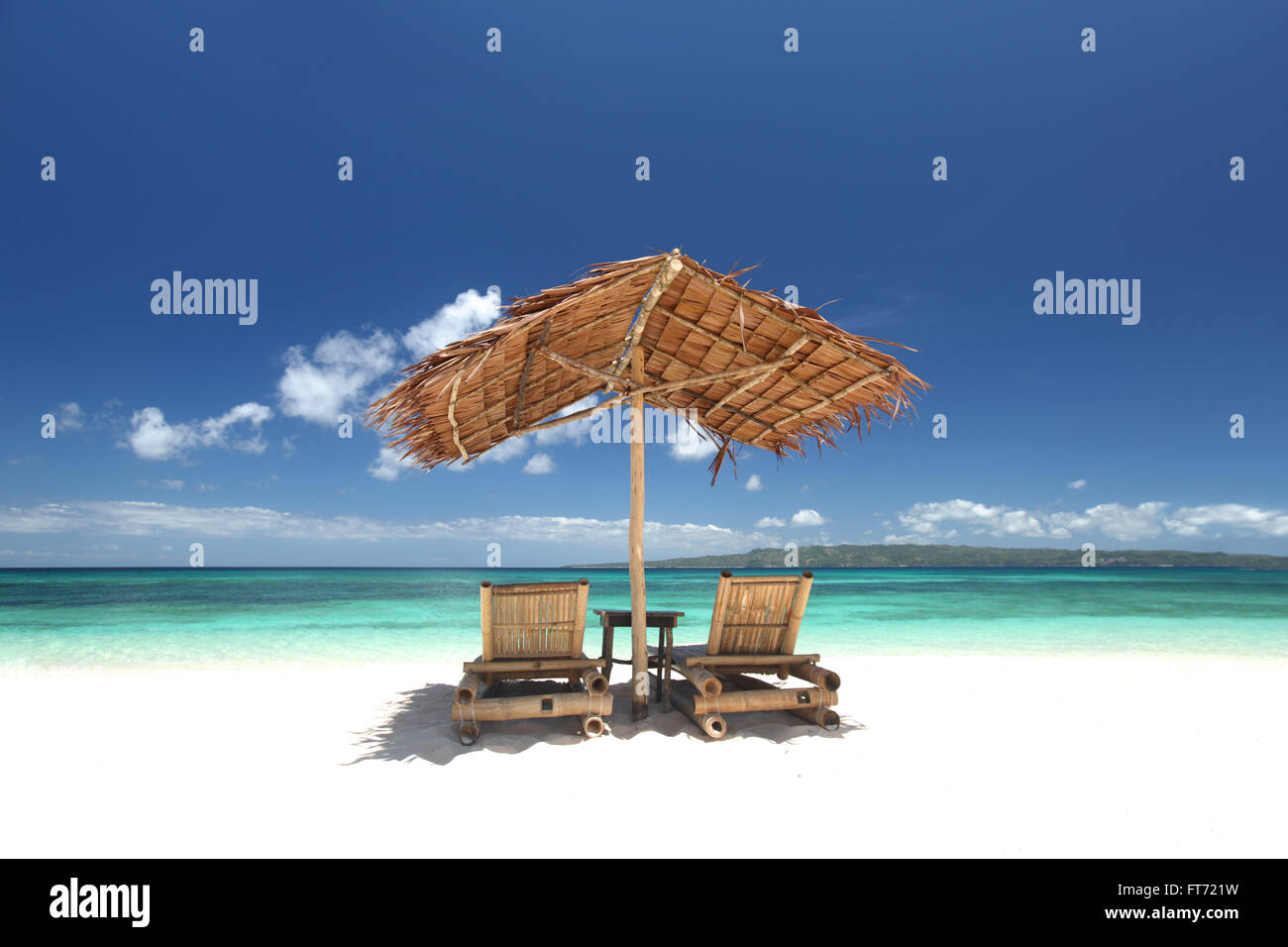 Relaxing couch chairs with straw parasol on white sandy beach at ...