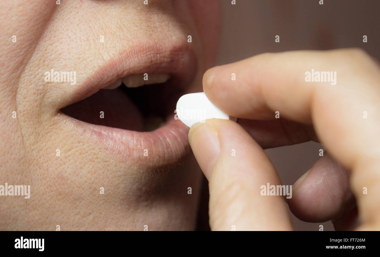 Woman taking pill red lips hi-res stock photography and images - Alamy