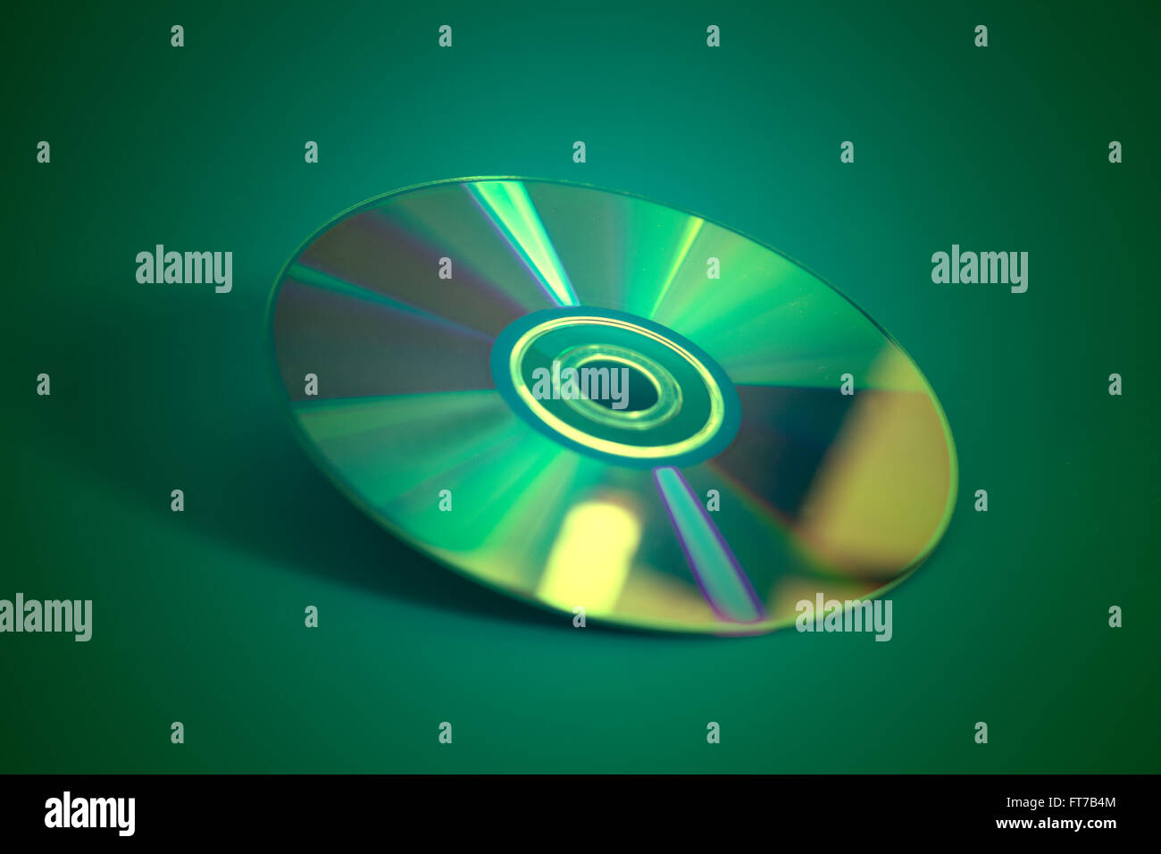 Compact disk on green background Stock Photo - Alamy