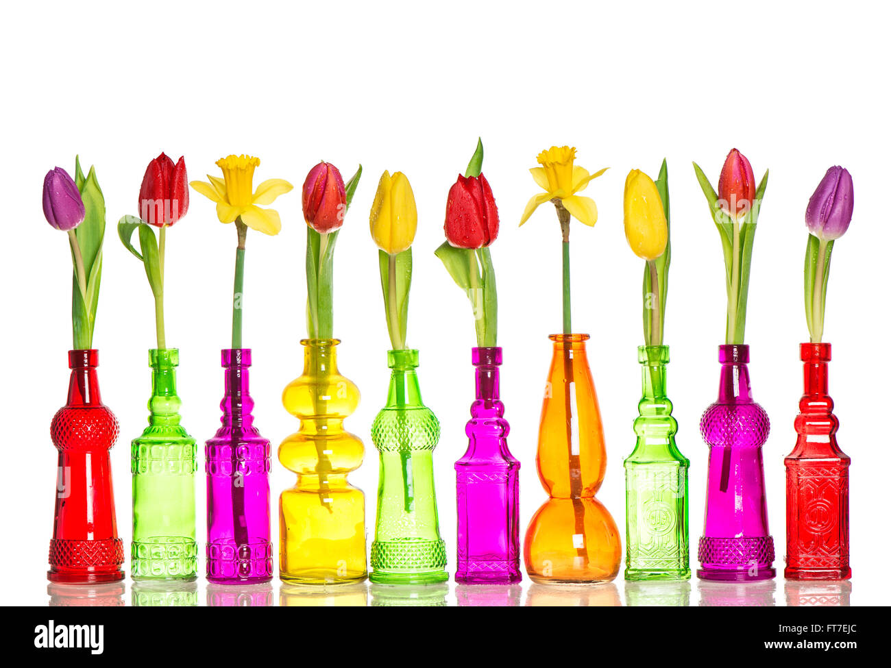 Spring flowers tulips and daffodils in color bottles on white ...
