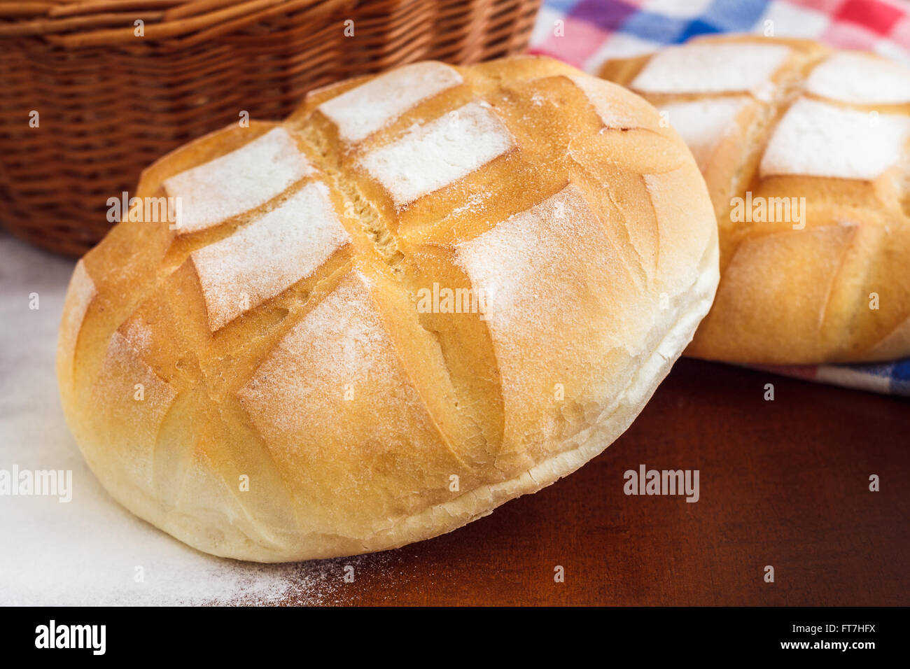 Round loaf of bread with kitchen rag, flour and weaved basket Stock ...