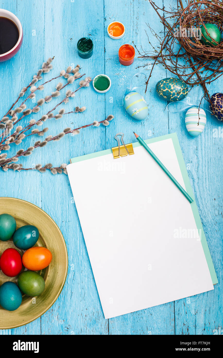 Easter in the office workplace on blue wooden table. Top view with copy ...